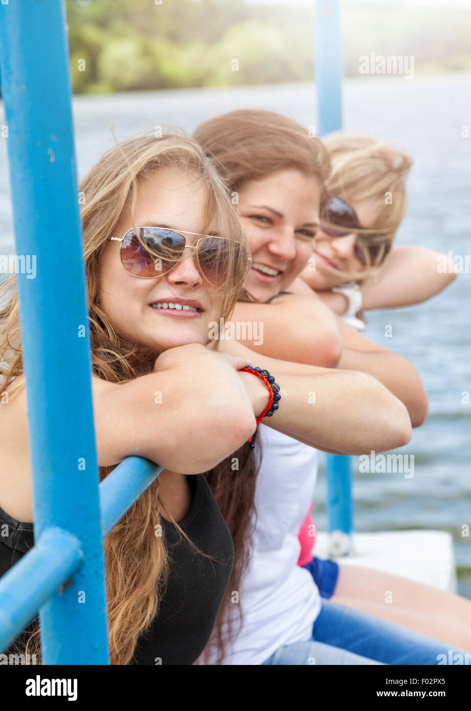 Three best friends having a good time outdoors by the water Stock Photo ...