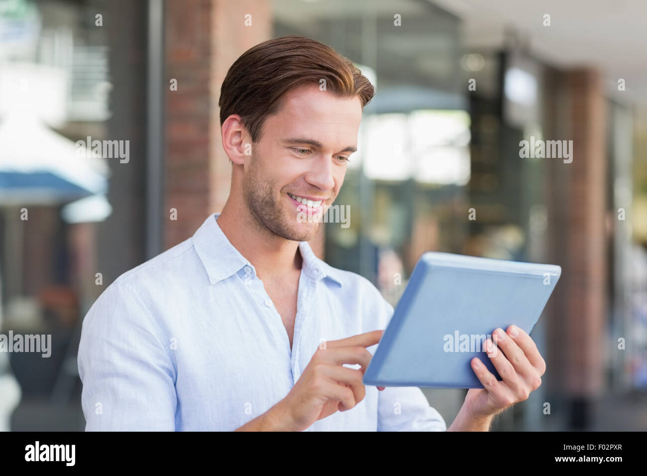 A happy smiling man using his tablet Stock Photo - Alamy