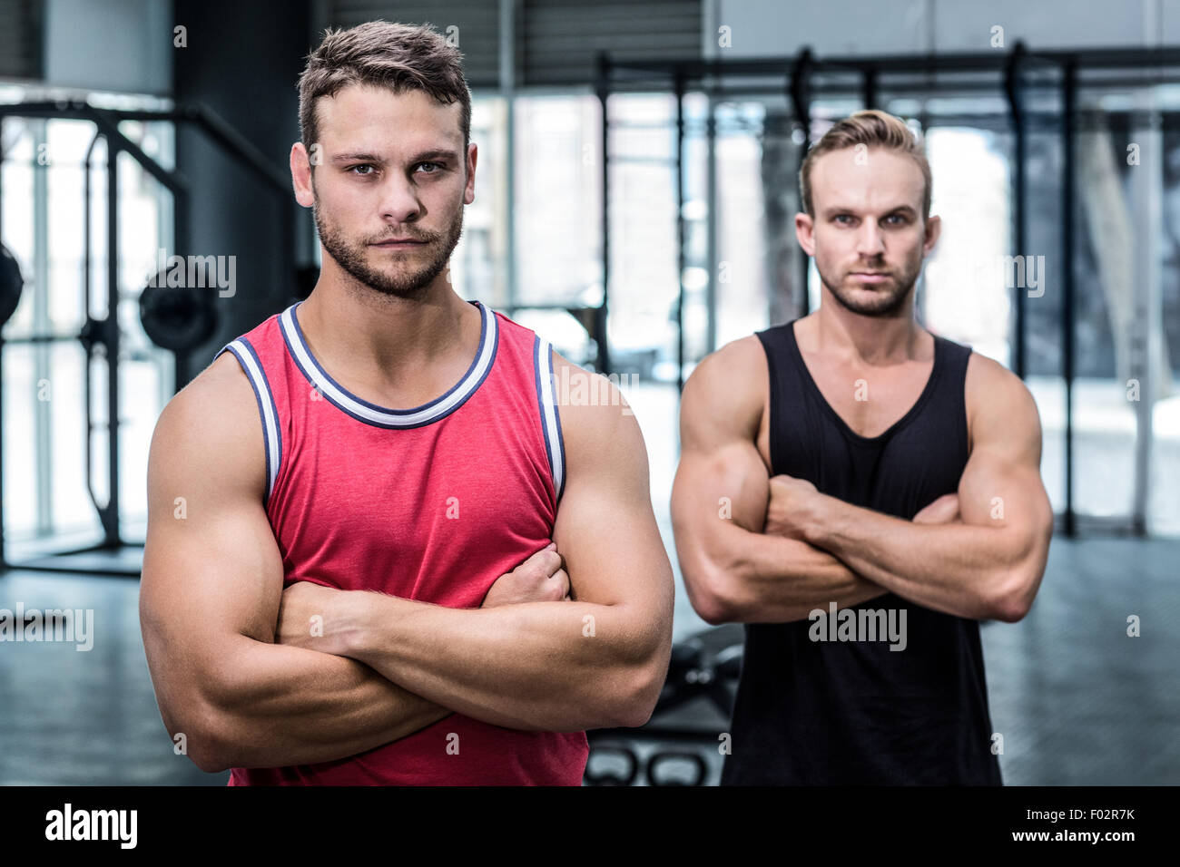 Two serious muscular men with arms crossed Stock Photo - Alamy