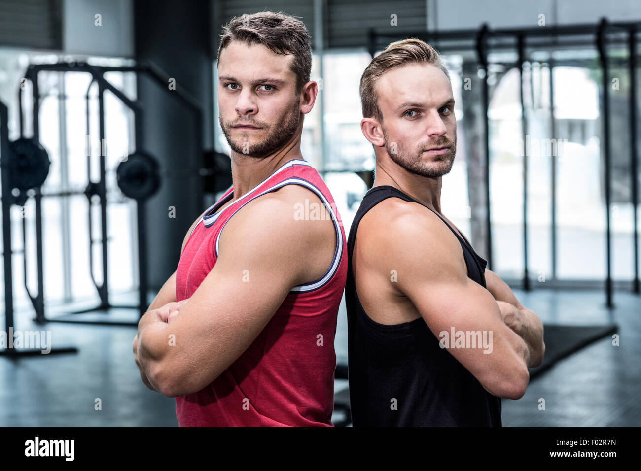 Two muscular men giving back to back Stock Photo - Alamy