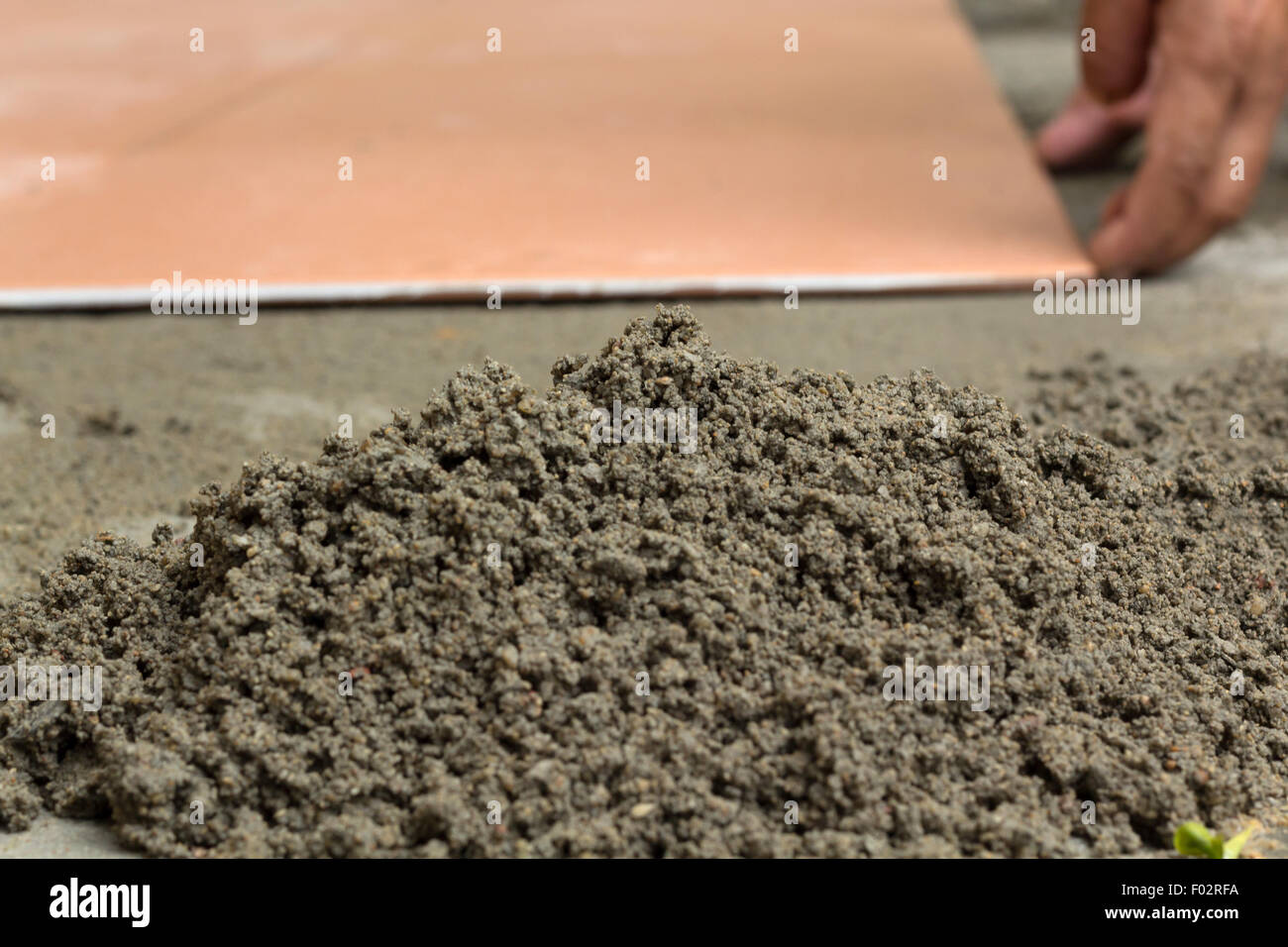 a tiler at work. bonding of floor tile with tile adhesive and filler ...