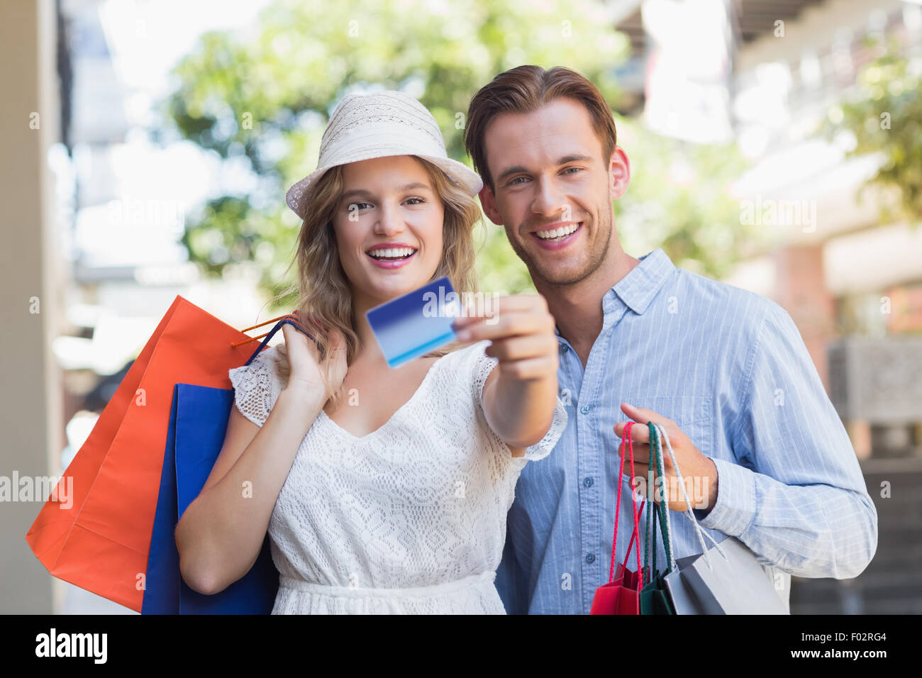Cute couple showing a credit card Stock Photo - Alamy
