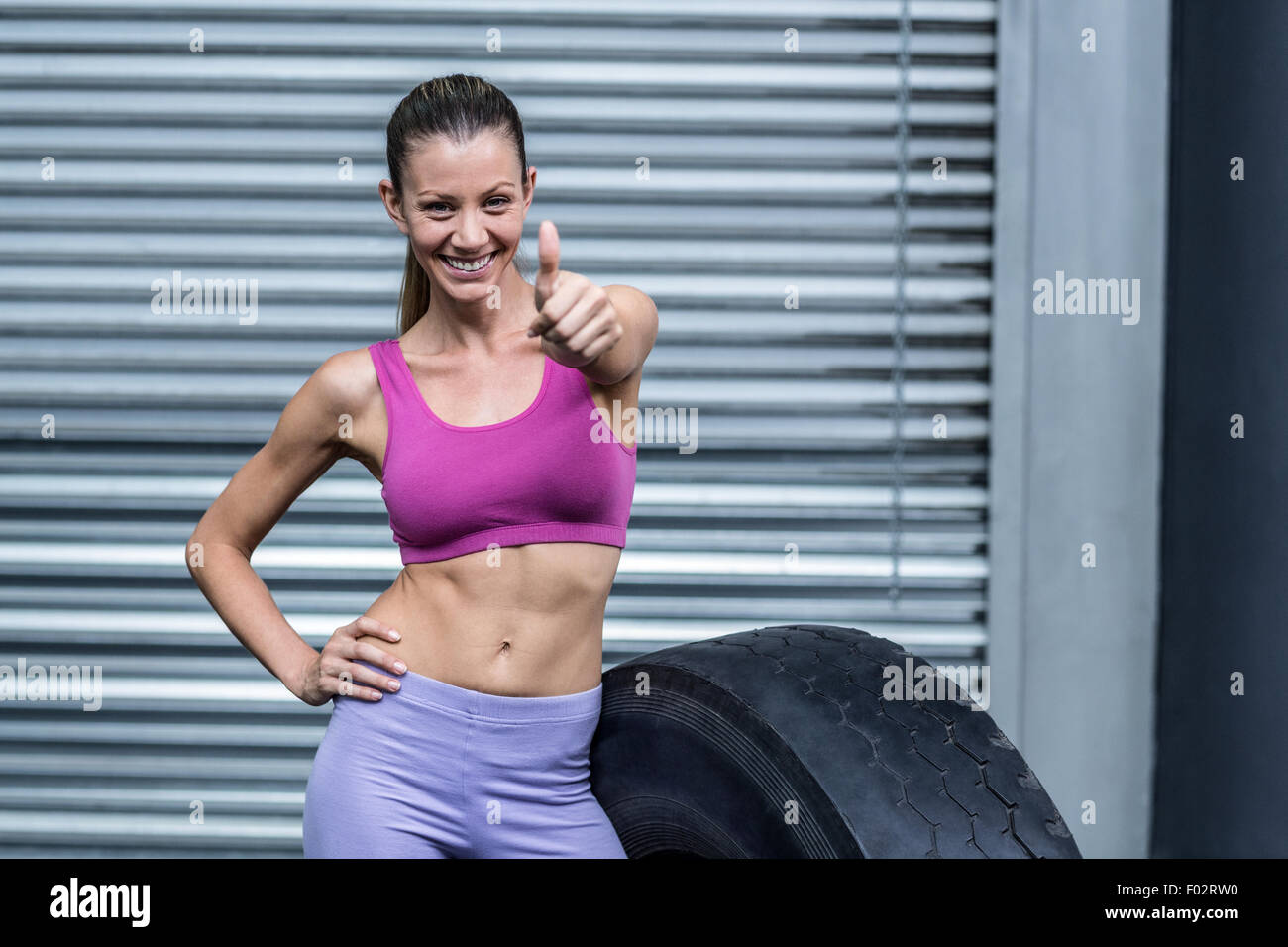 Smiling muscular woman gesturing thumbs up Stock Photo - Alamy
