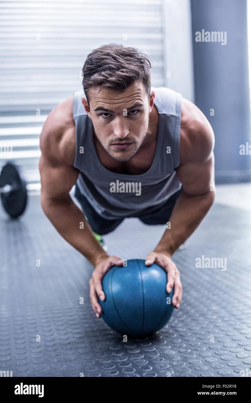 Muscular man on a plank position with a ball Stock Photo - Alamy