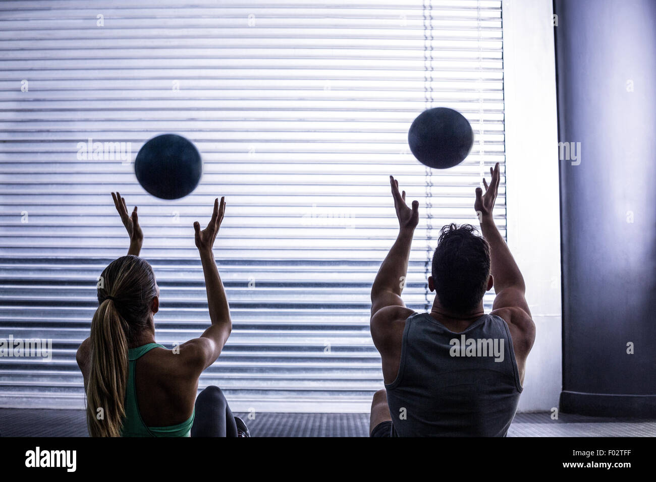 Muscular couple throwing ball in the air Stock Photo - Alamy