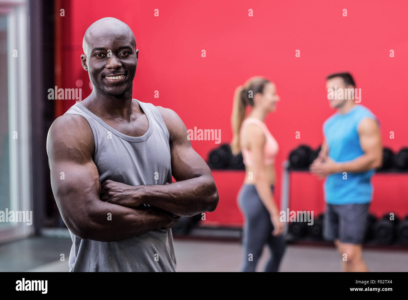 Smiling muscular man with arms crossed Stock Photo - Alamy