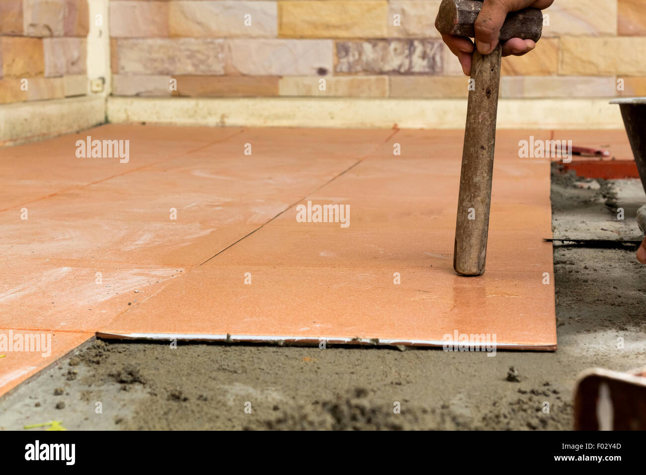 a tiler at work. bonding of floor tile with tile adhesive and filler ...