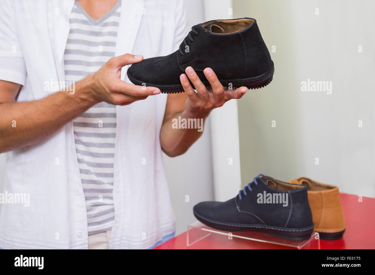 Young man holding a shoe Stock Photo - Alamy