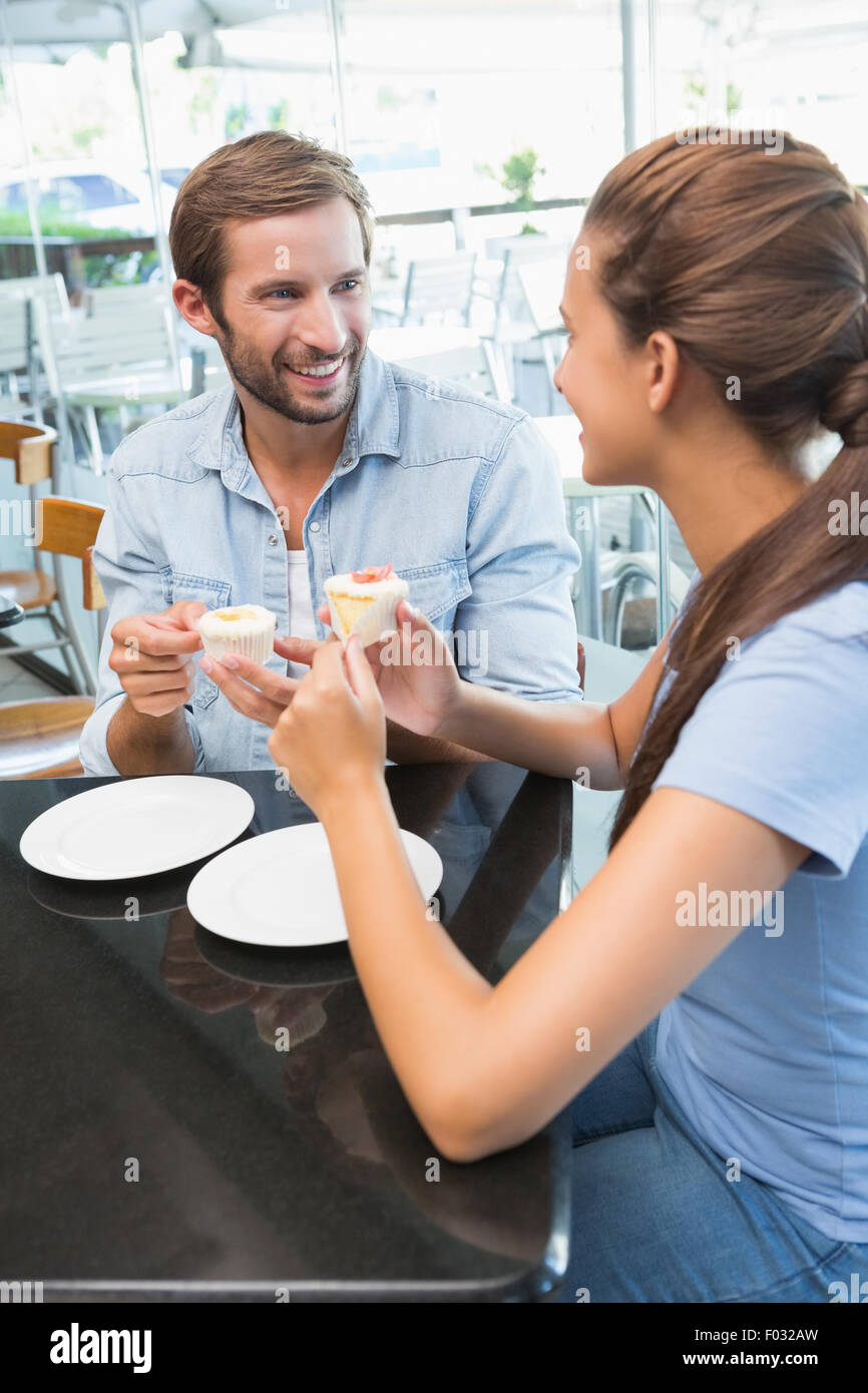 Young happy couple eating cake Stock Photo - Alamy