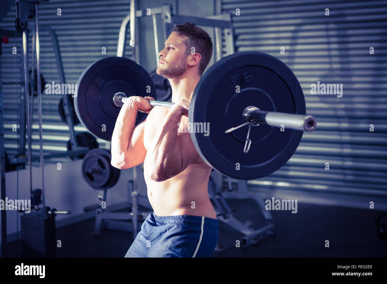 Muscular man lifting a barbell Stock Photo - Alamy