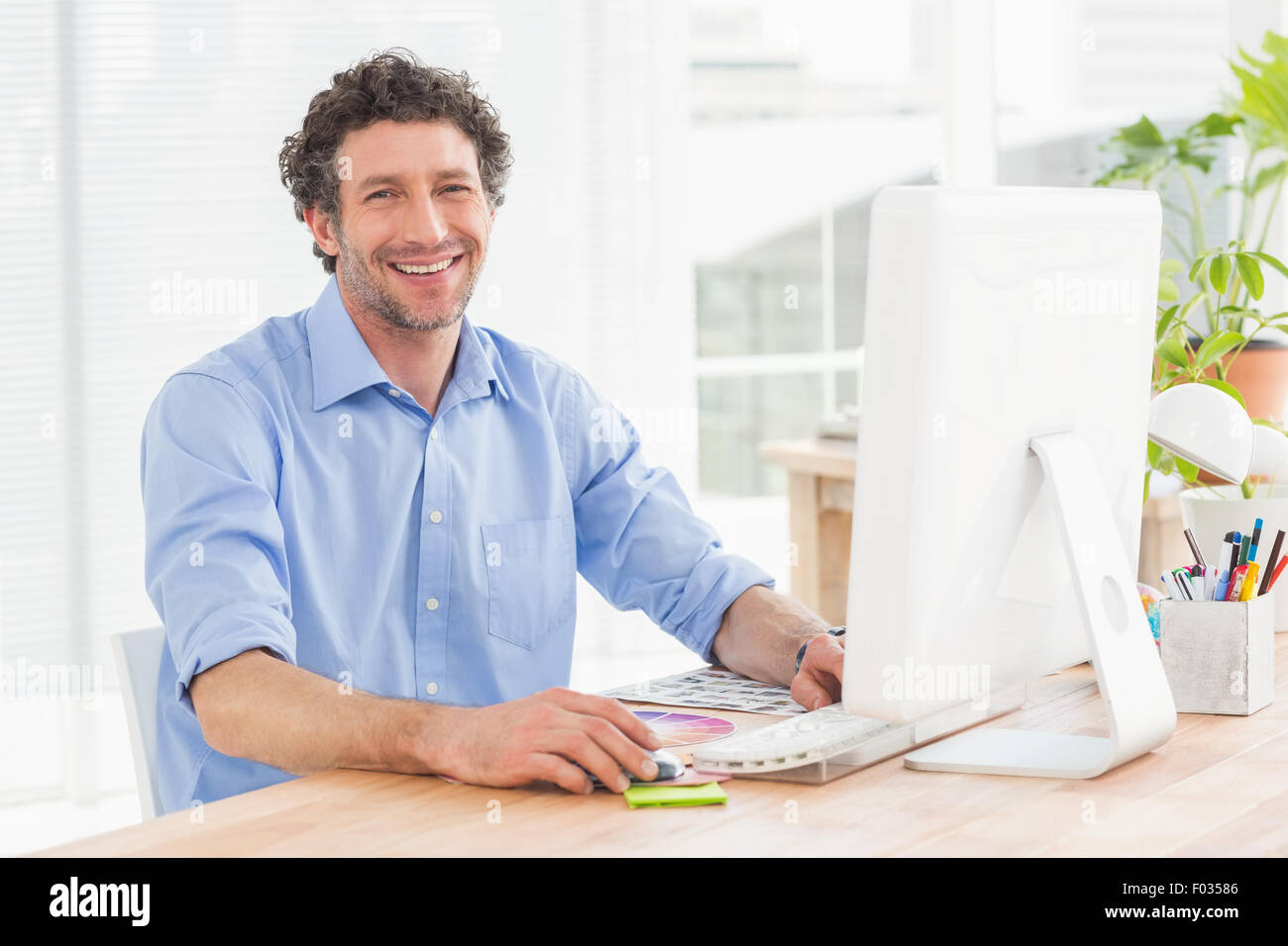 Casual businessman using computer in office Stock Photo - Alamy