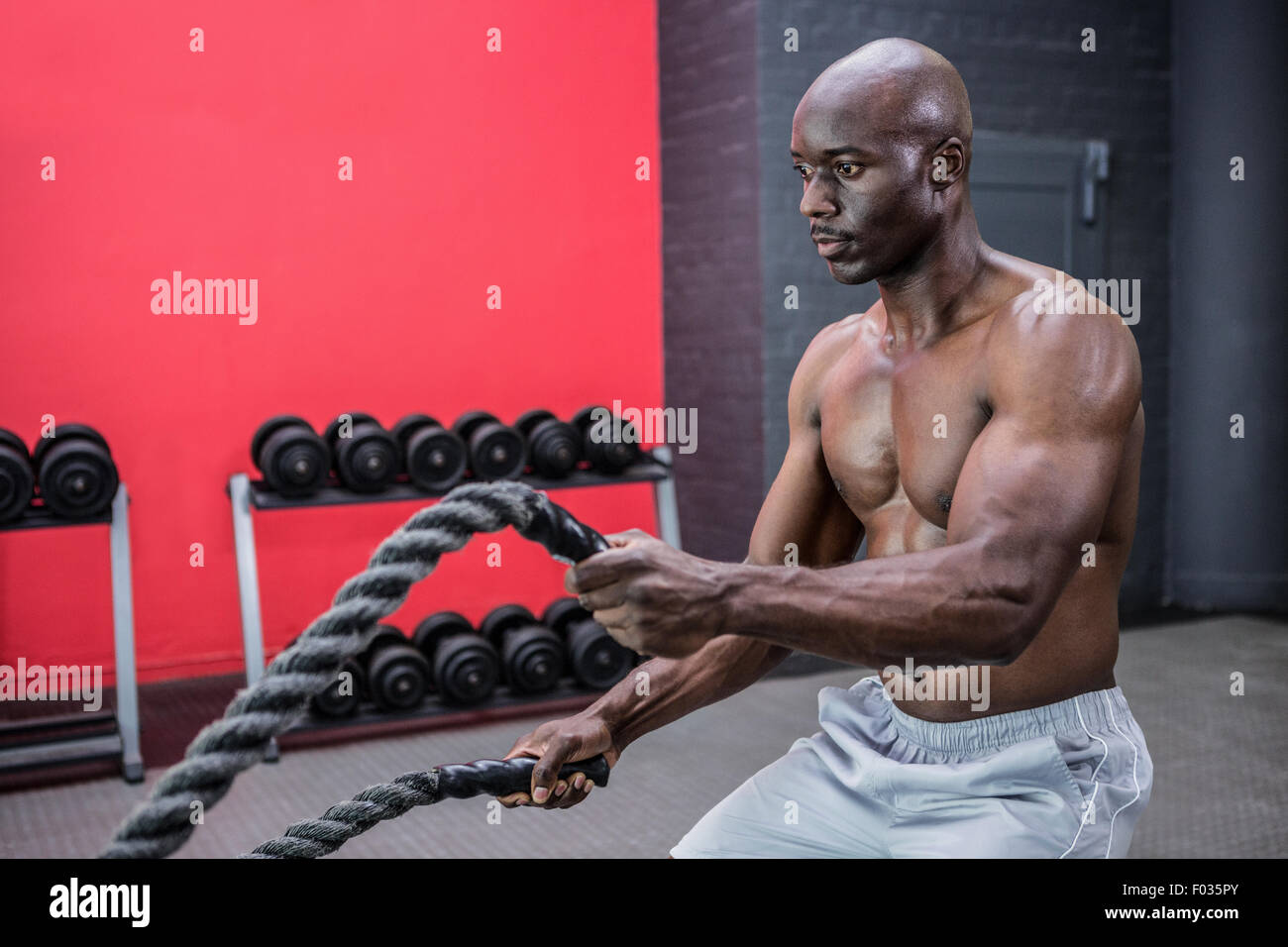 Young Bodybuilder working with ropes Stock Photo - Alamy