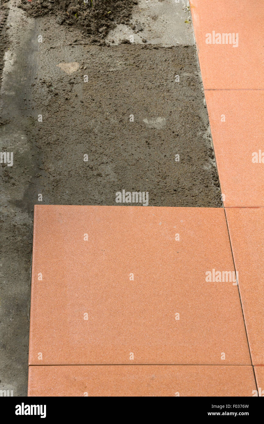 a tiler at work. bonding of floor tile with tile adhesive and filler ...