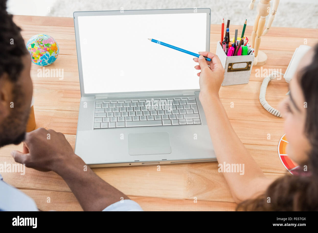 Colleagues brainstorming and pointing laptop screen Stock Photo - Alamy