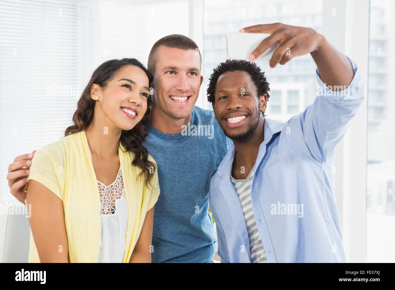 Smiling colleagues taking selfies Stock Photo - Alamy