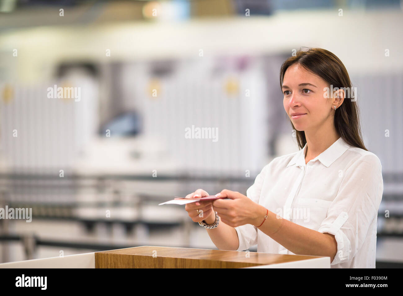 Beautiful woman with passports and boarding passes at the front desk at ...