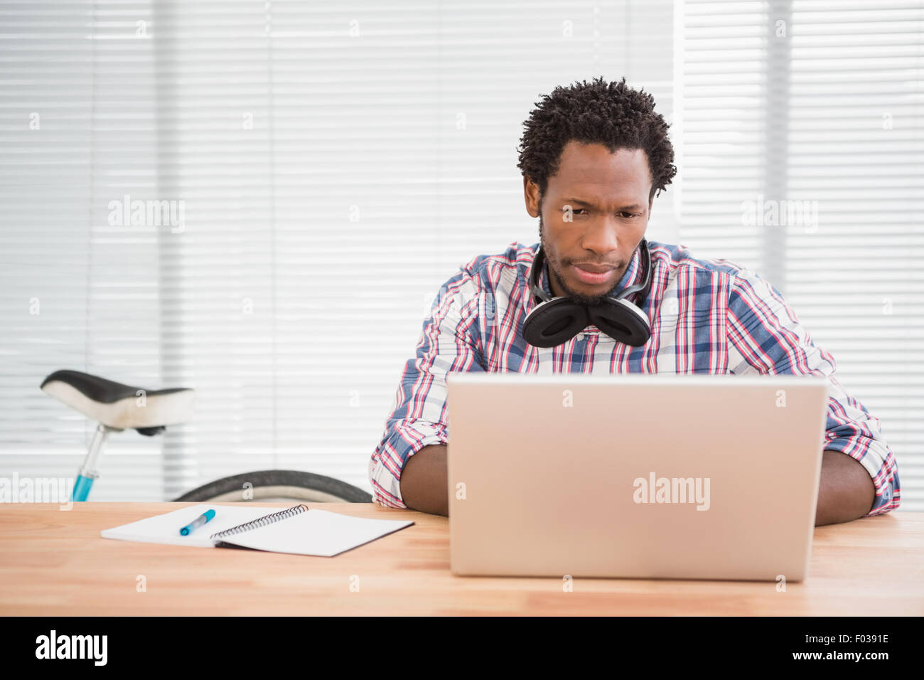 Young businessman looks confused at his laptop Stock Photo - Alamy