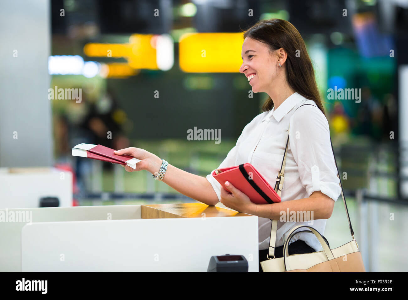 Young girl with passports and boarding passes at the front desk at ...