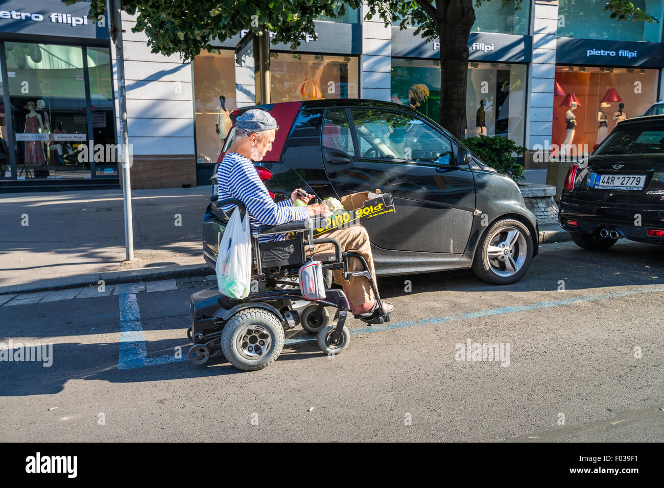 A young disabled man in a battery powered electric motorised wheelchair ...