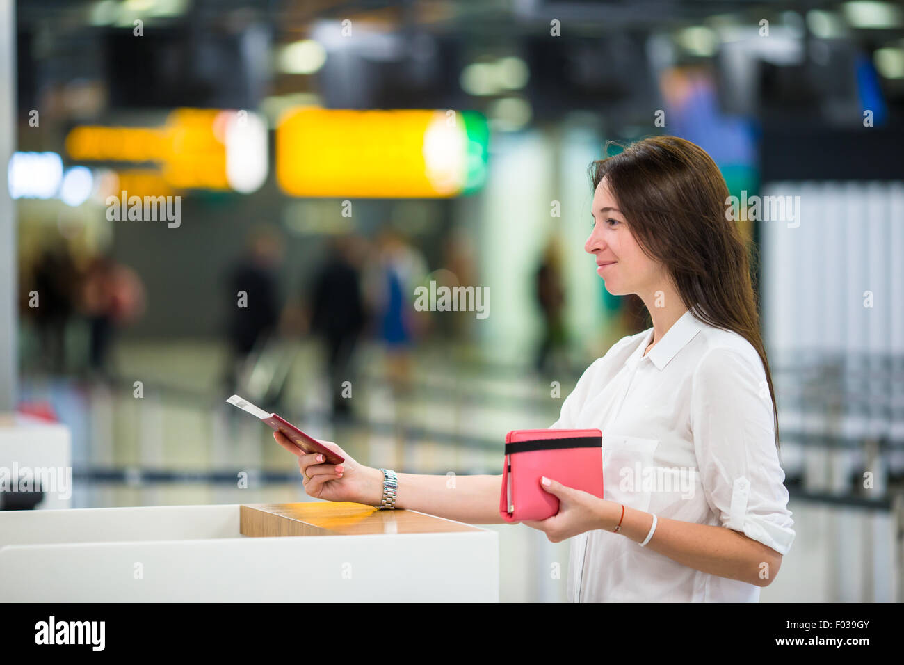 Beautiful woman with passports and boarding passes at the front desk at ...