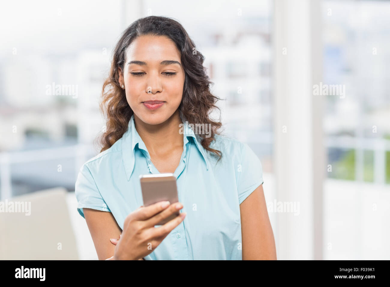 Happy young creative businesswoman texting Stock Photo - Alamy