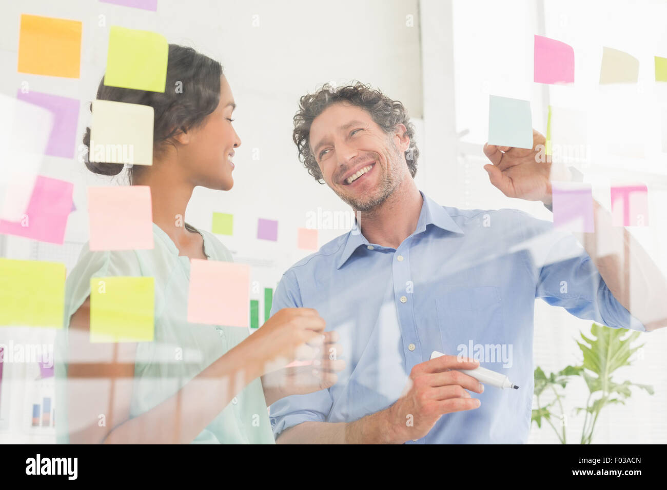 Puzzled business team looking post its on the wall Stock Photo - Alamy