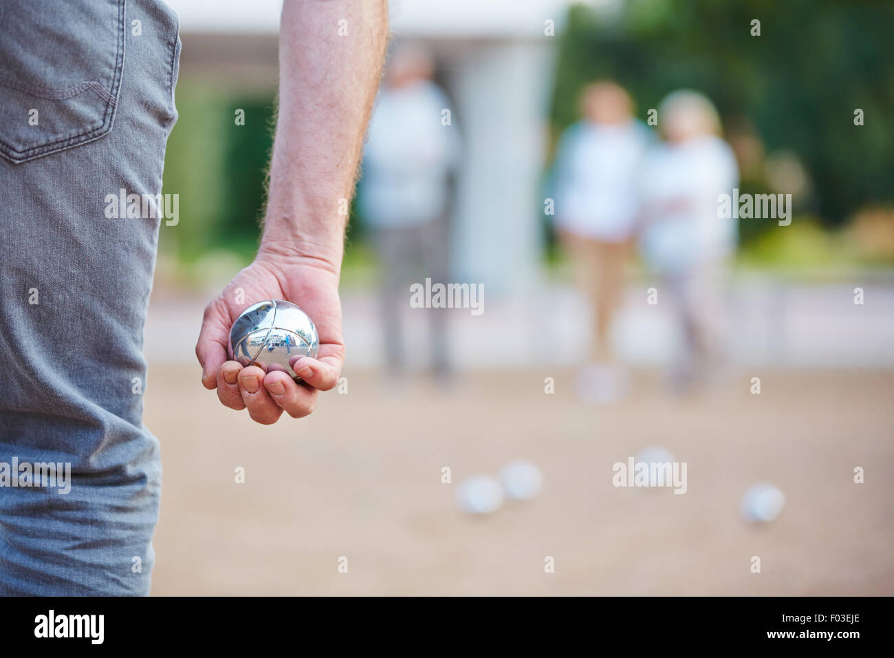 Hand holding a metal ball for playing boule Stock Photo - Alamy
