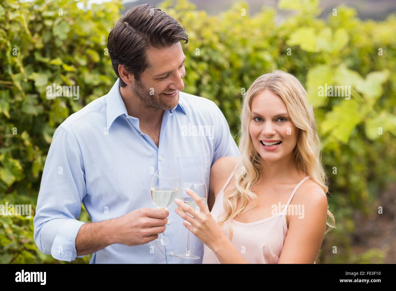Young happy couple smiling at camera and toasting Stock Photo - Alamy
