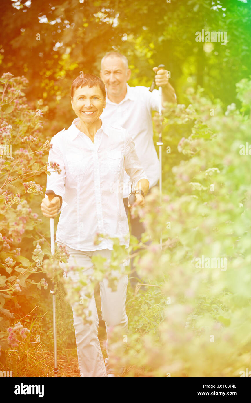 Two happy senior people walking in nature in summer Stock Photo - Alamy