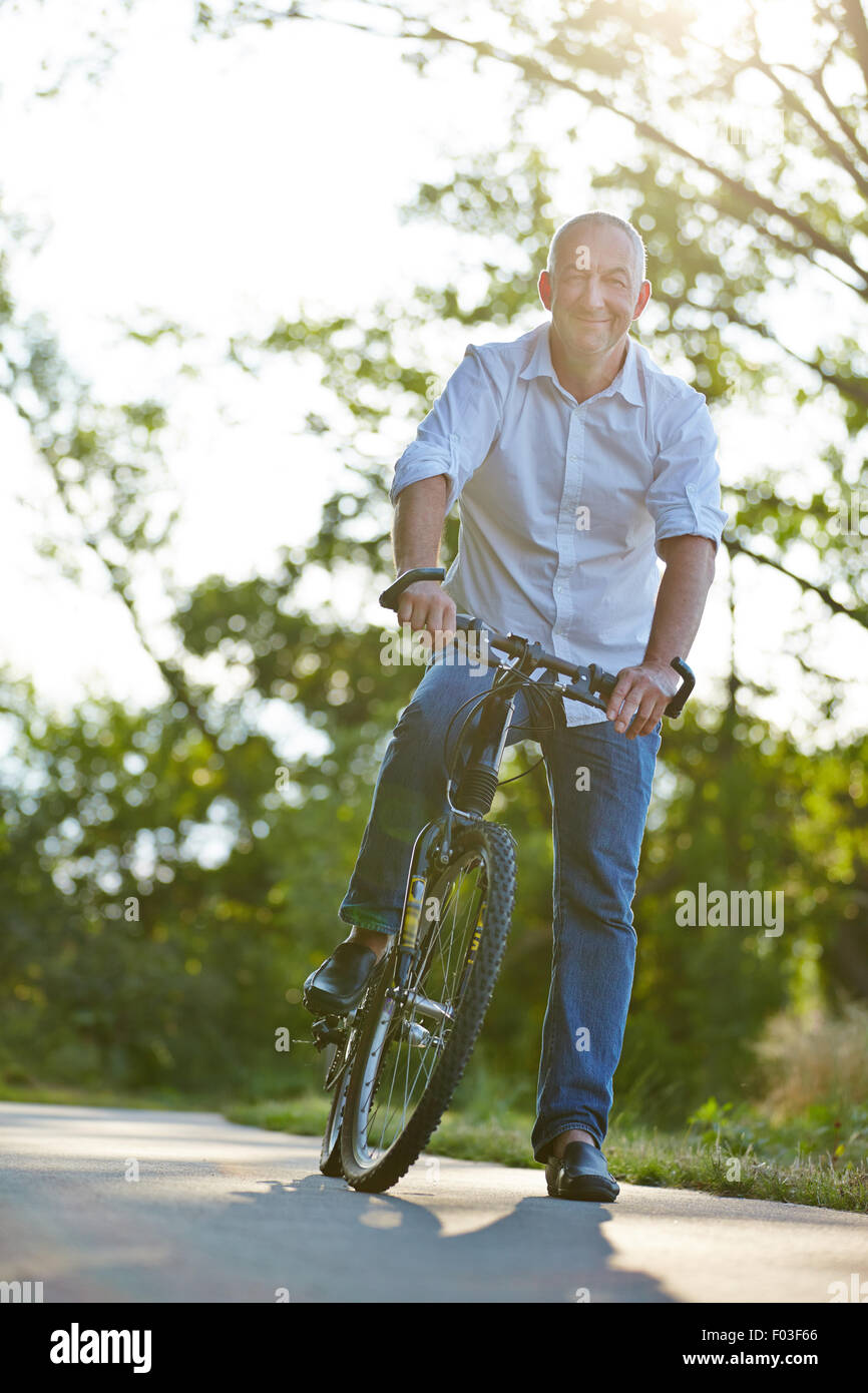 Happy man riding mountainbike in summer in nature Stock Photo - Alamy
