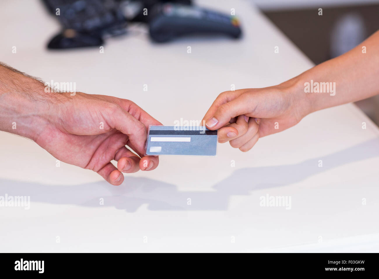 Woman giving credit card to cashier Stock Photo - Alamy