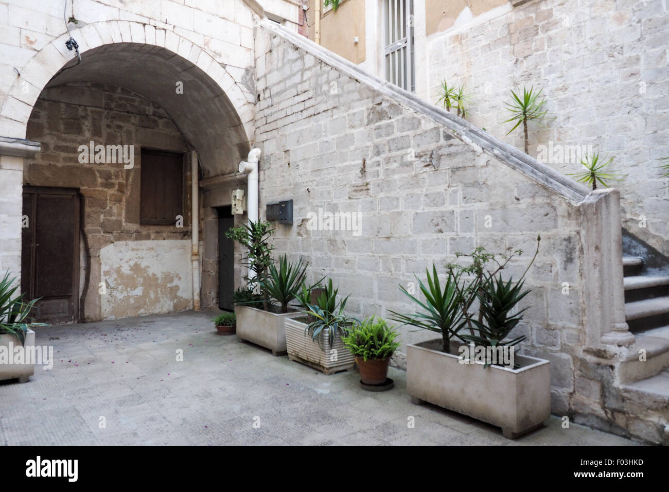 A limestone courtyard with steps and potted plants Stock Photo - Alamy