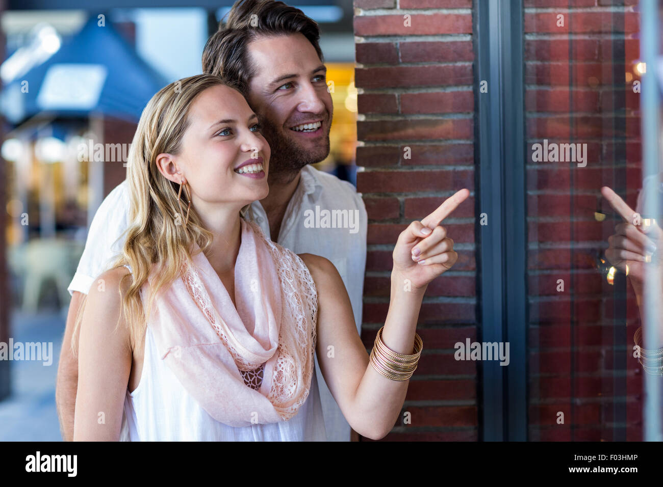 Smiling couple going window shopping and pointing at window Stock Photo ...