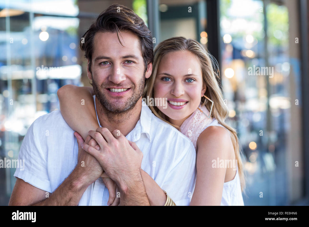 Smiling woman putting arm around her boyfriend Stock Photo - Alamy