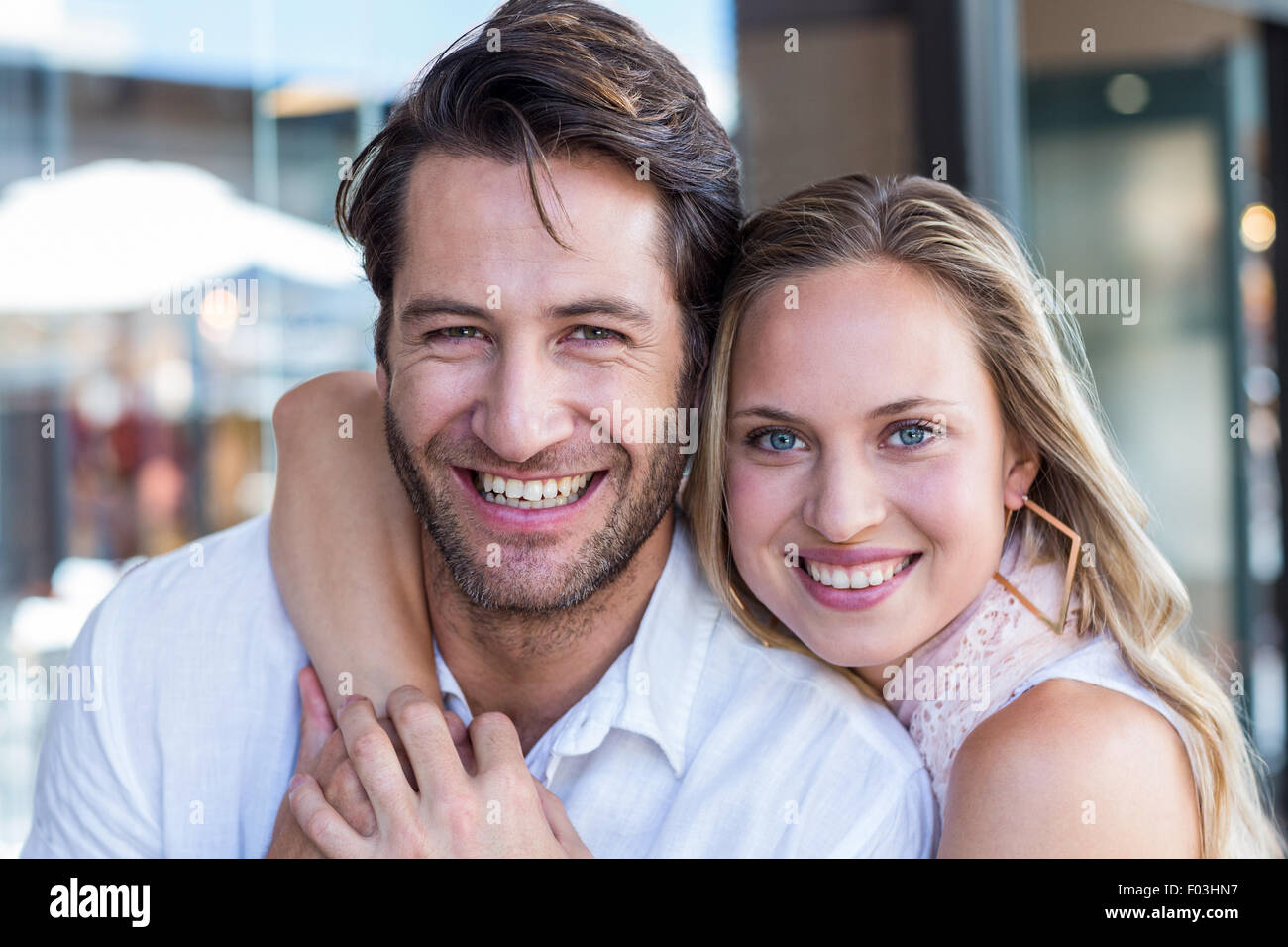 Smiling woman putting arm around her boyfriend Stock Photo - Alamy