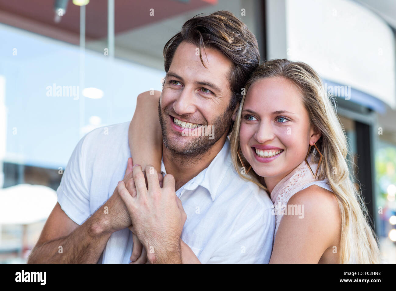 Smiling woman putting arm around her boyfriend Stock Photo - Alamy