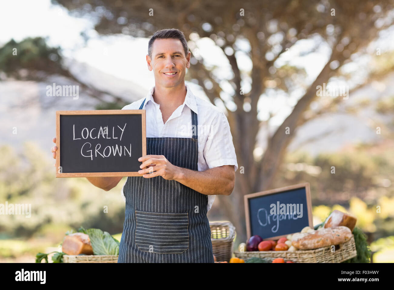 Smiling farmer holding a locally grown sign Stock Photo - Alamy