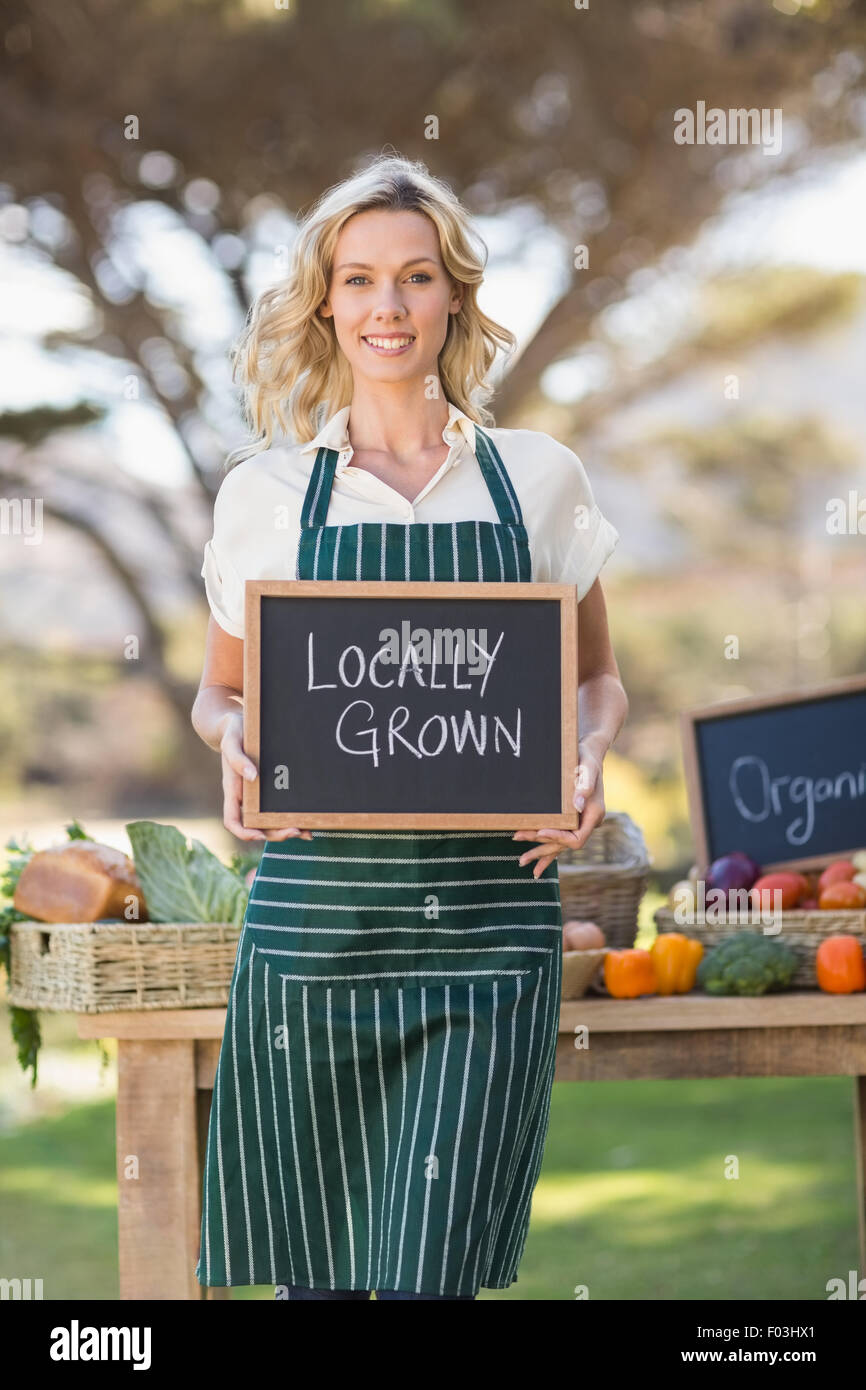 Smiling farmer woman holding a locally grown sign Stock Photo - Alamy