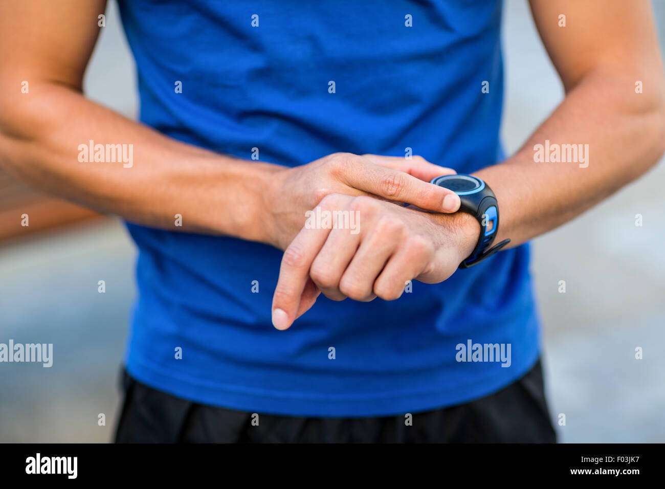An handsome athlete looking at his watch Stock Photo - Alamy