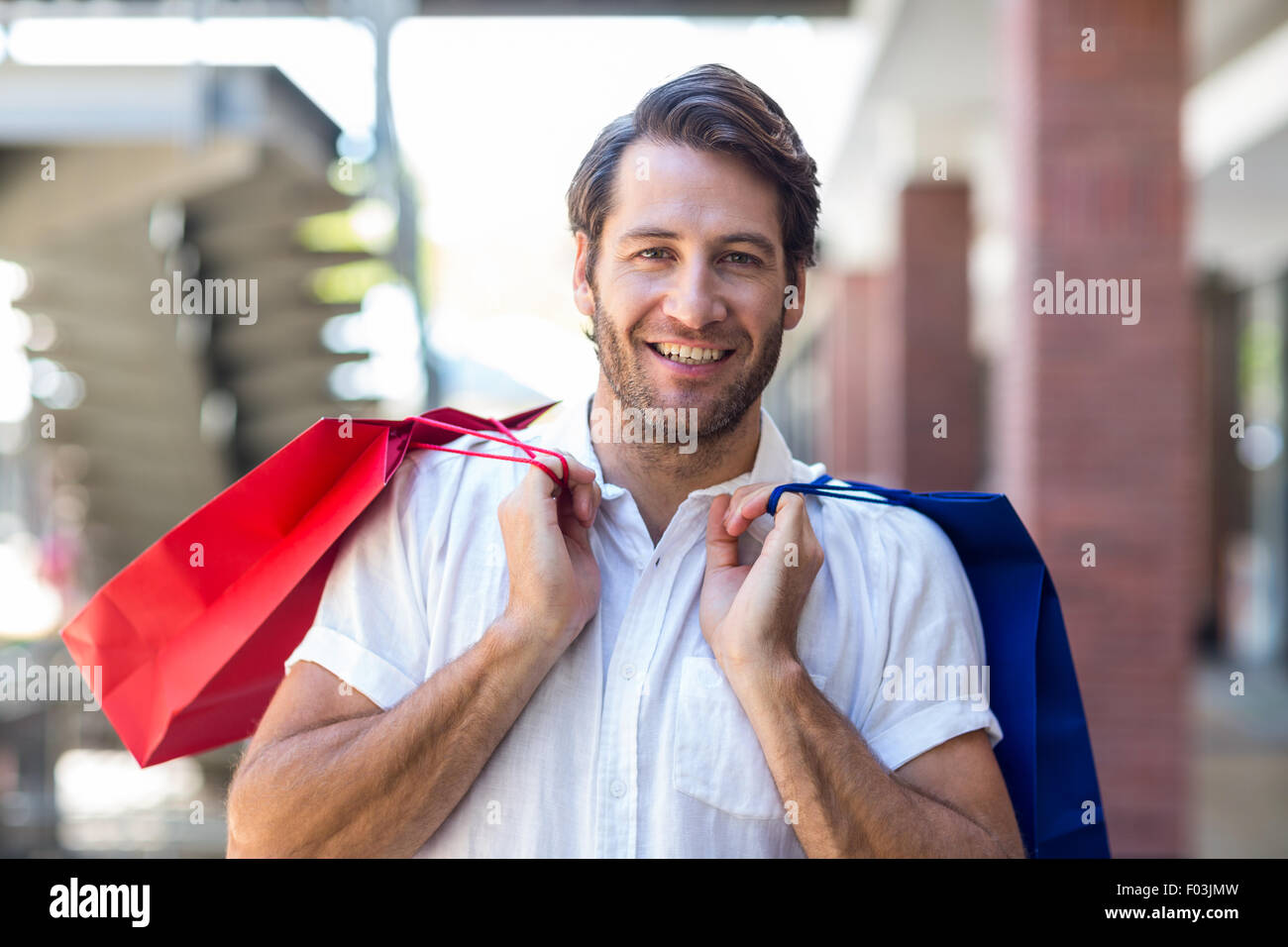 A happy smiling man with shopping bags Stock Photo - Alamy