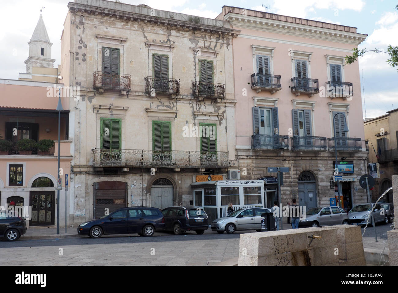 Contrasting facades of apartment buildings, one in disrepair and the ...