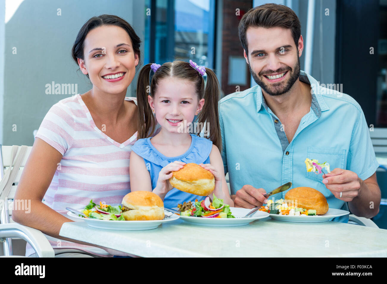 Portrait of a family eating at the restaurant Stock Photo - Alamy