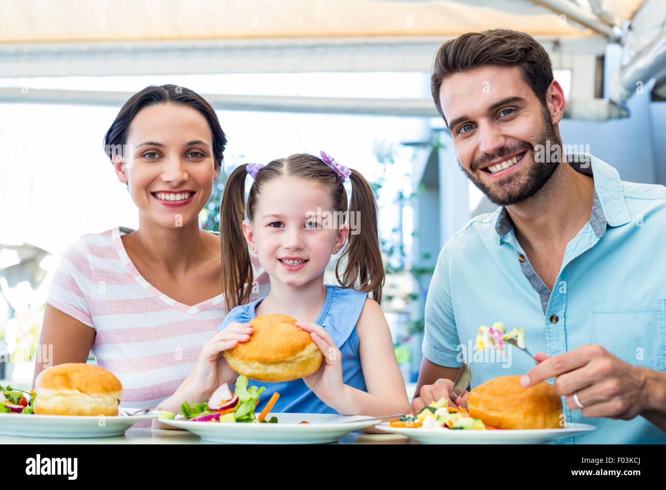 Portrait of a family eating at the restaurant Stock Photo - Alamy