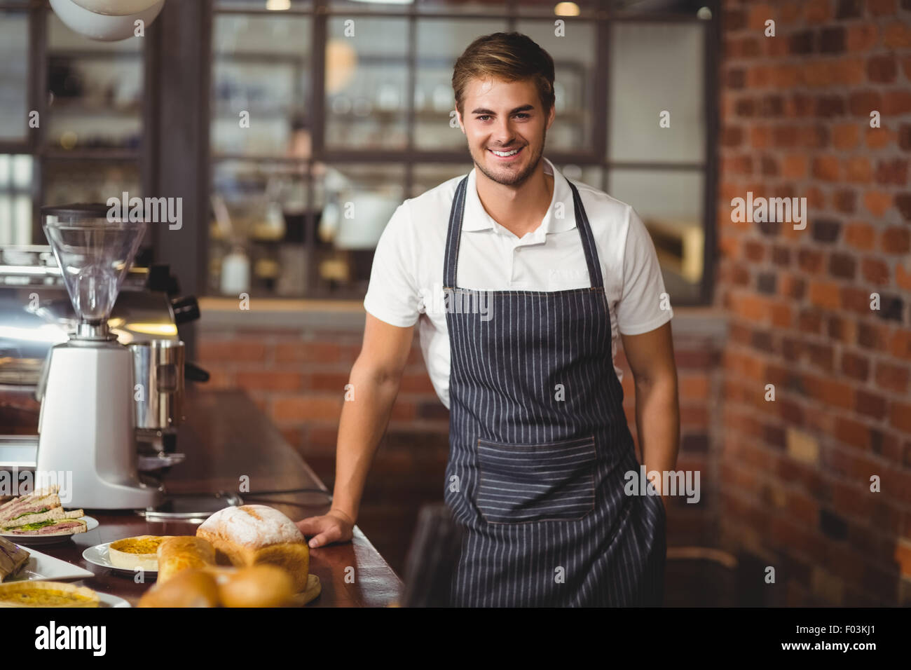 Handsome waiter leaning on a food table Stock Photo - Alamy