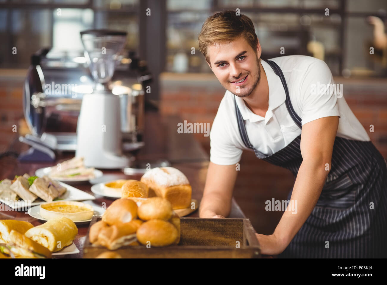 Handsome waiter leaning on a food table Stock Photo - Alamy
