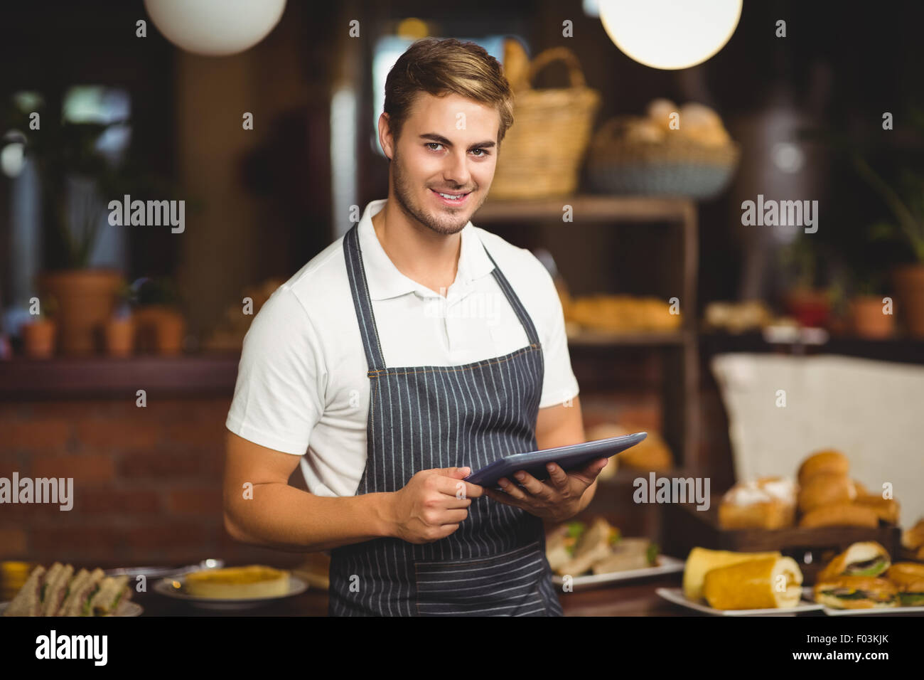 Handsome waiter holding a tablet Stock Photo - Alamy