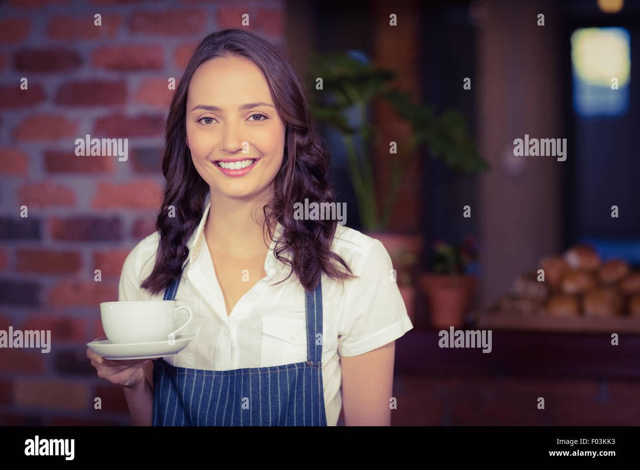 Pretty waitress holding a cup of coffee Stock Photo - Alamy