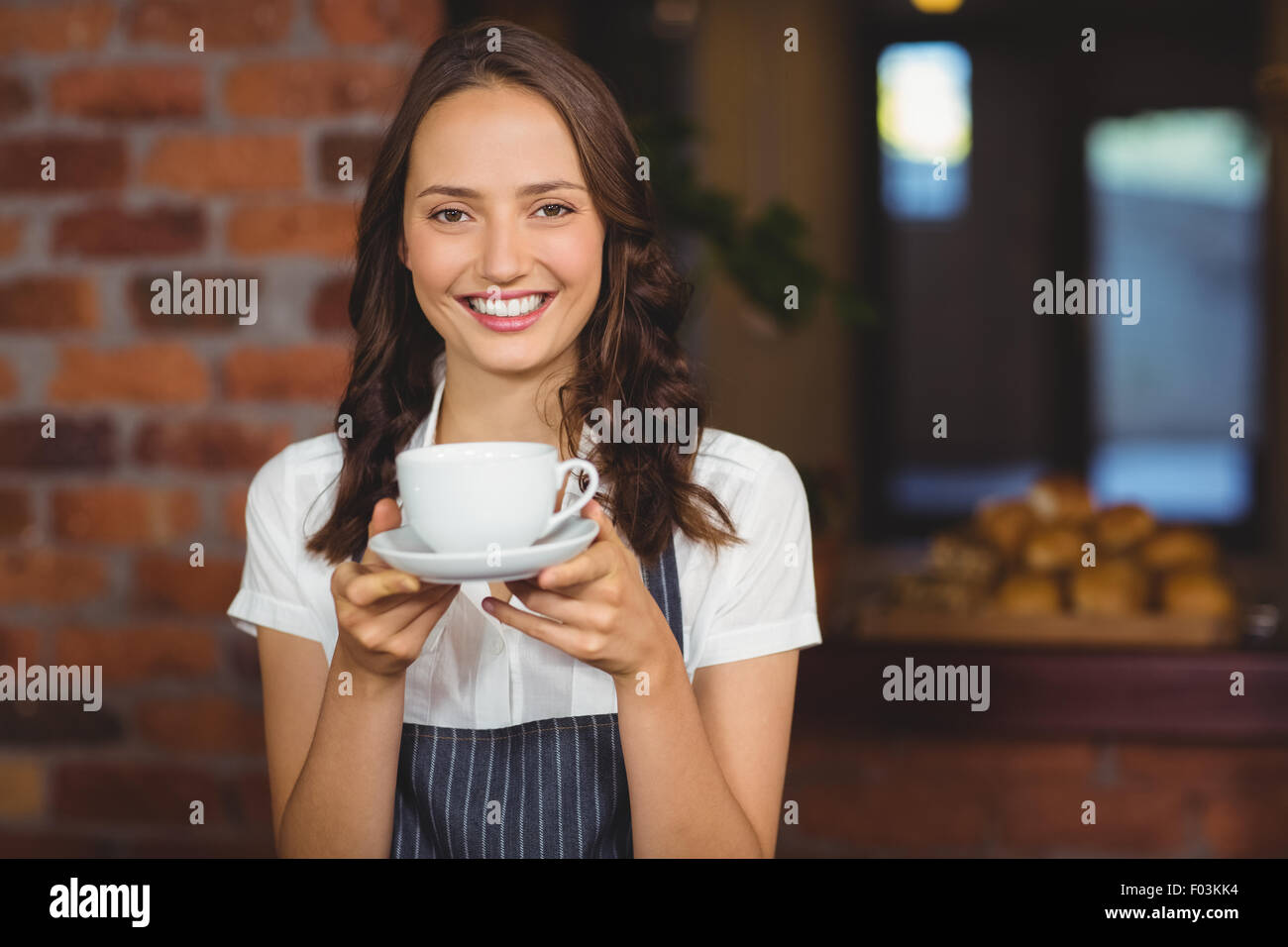 Pretty waitress offering a cup of coffee Stock Photo - Alamy