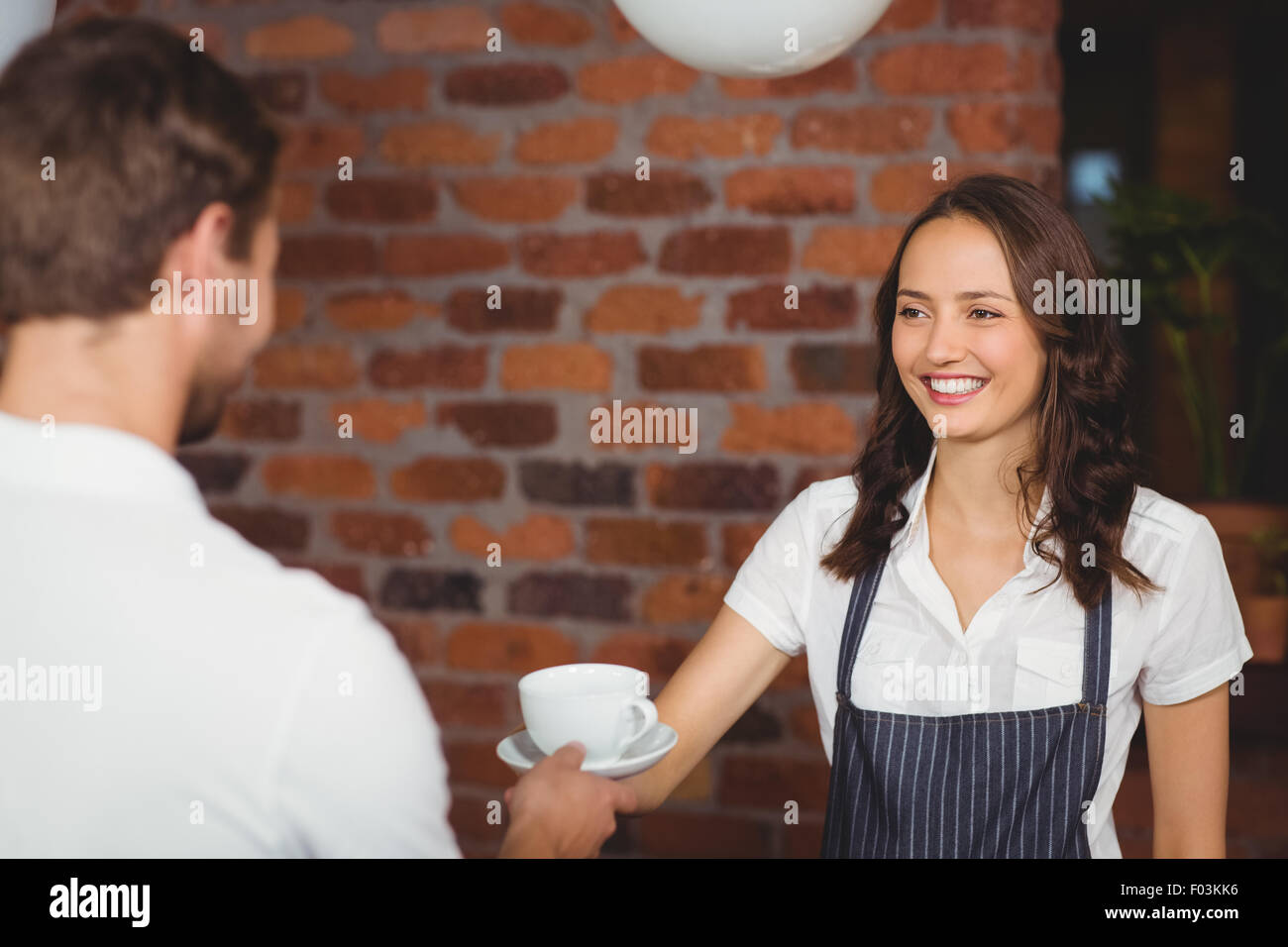 Pretty smiling barista serving a customer Stock Photo - Alamy