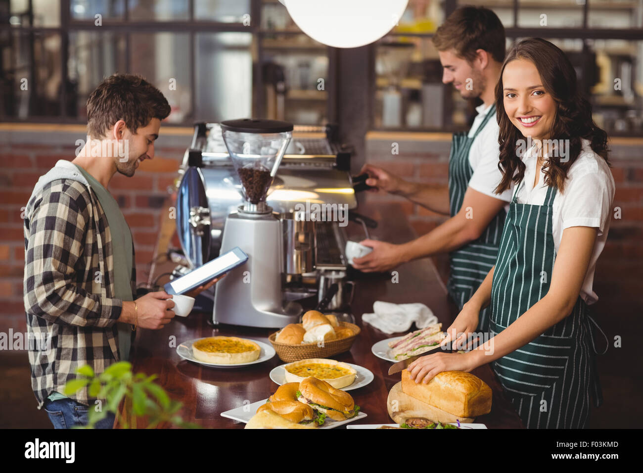 Smiling waiters serving a client Stock Photo - Alamy